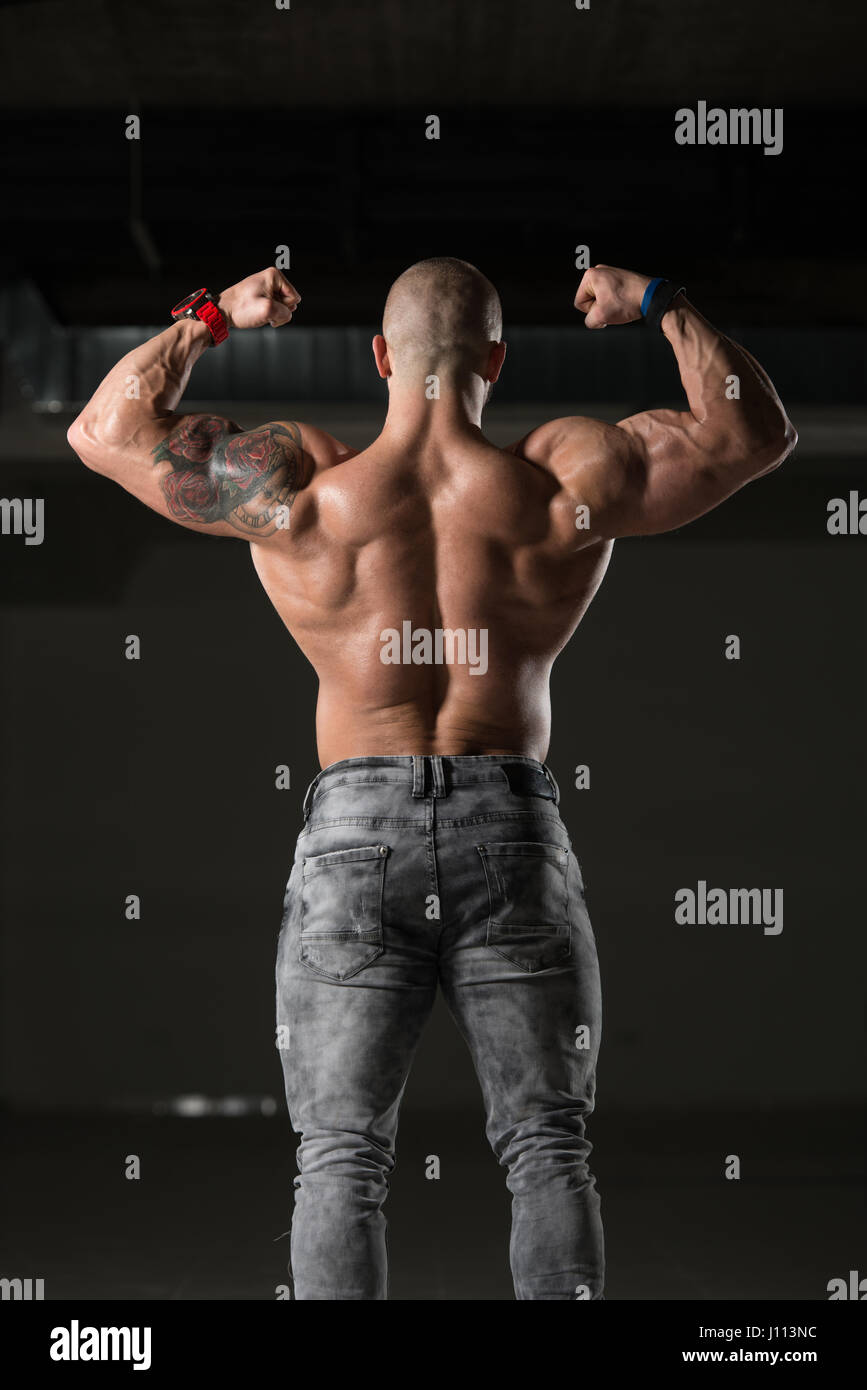 Handsome Young Man Standing Strong In Pants And Flexing Muscles ...