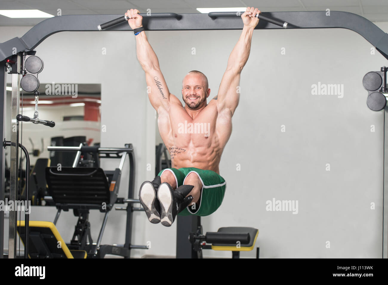 Young Man Performing Hanging Leg Raises Exercise - One Of The Most ...
