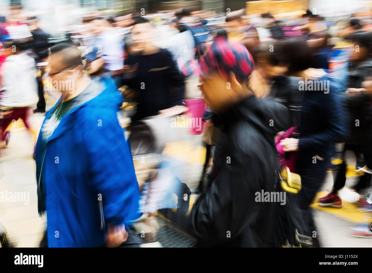 crowd of people in motion blur crossing a street in the city Stock ...