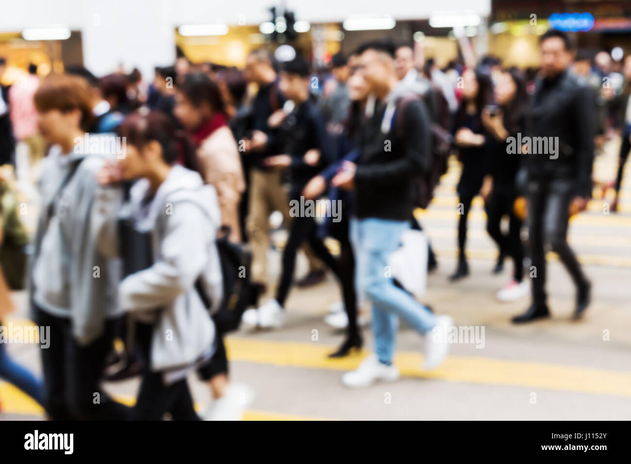 crowds of people crossing a city street out of focus Stock Photo - Alamy