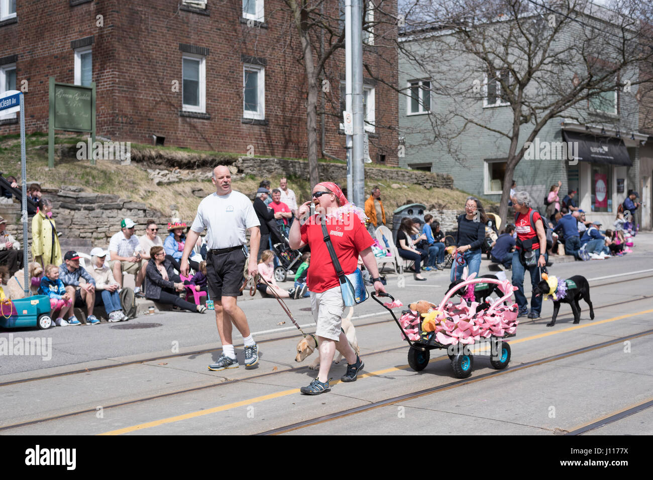 a man dragging a cart decorated with pink bow ties as Easter basket ...