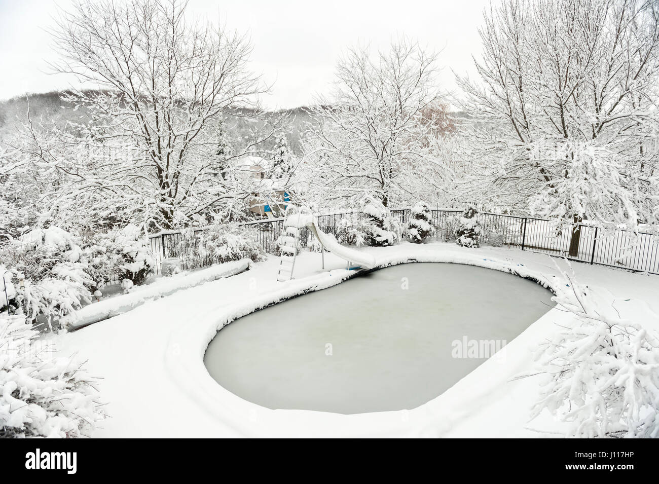 Backyard swimming pool in winter, after heavy snow fall, storm, covered ...