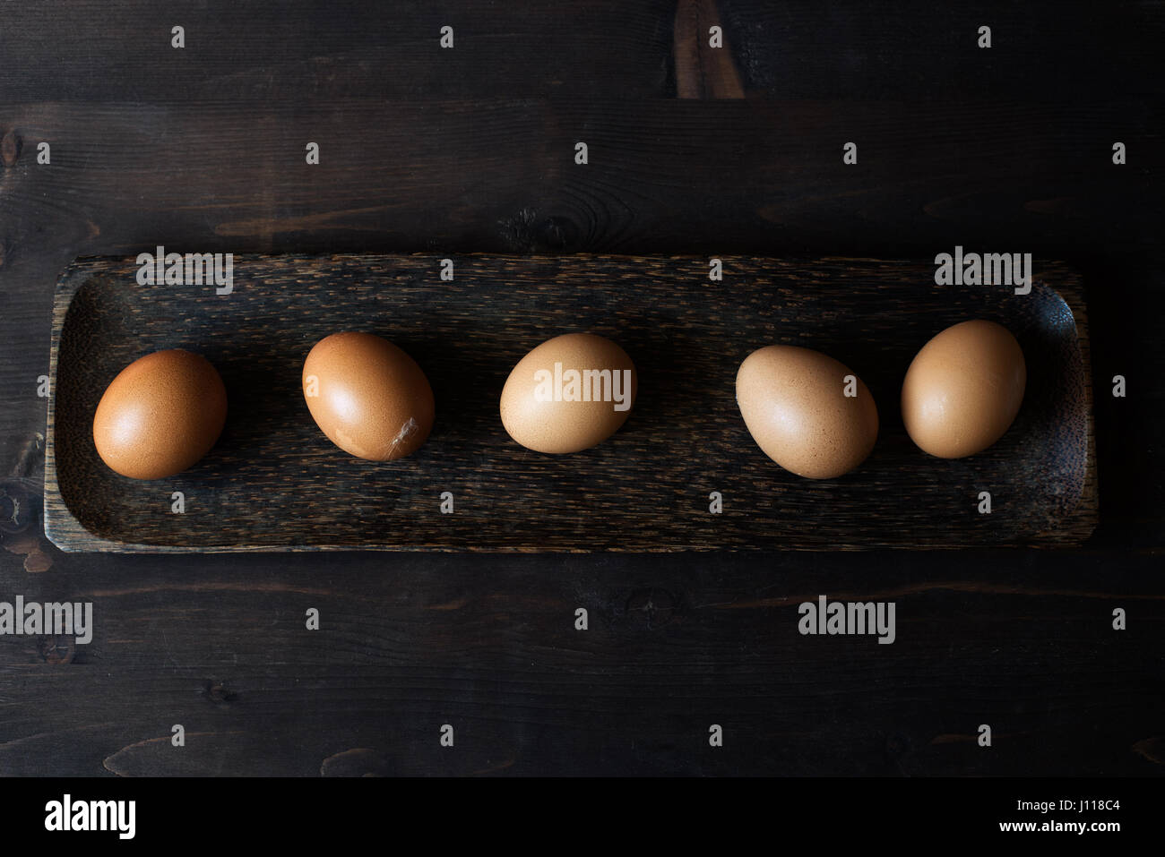 Five eggs on a wooden dish Stock Photo - Alamy