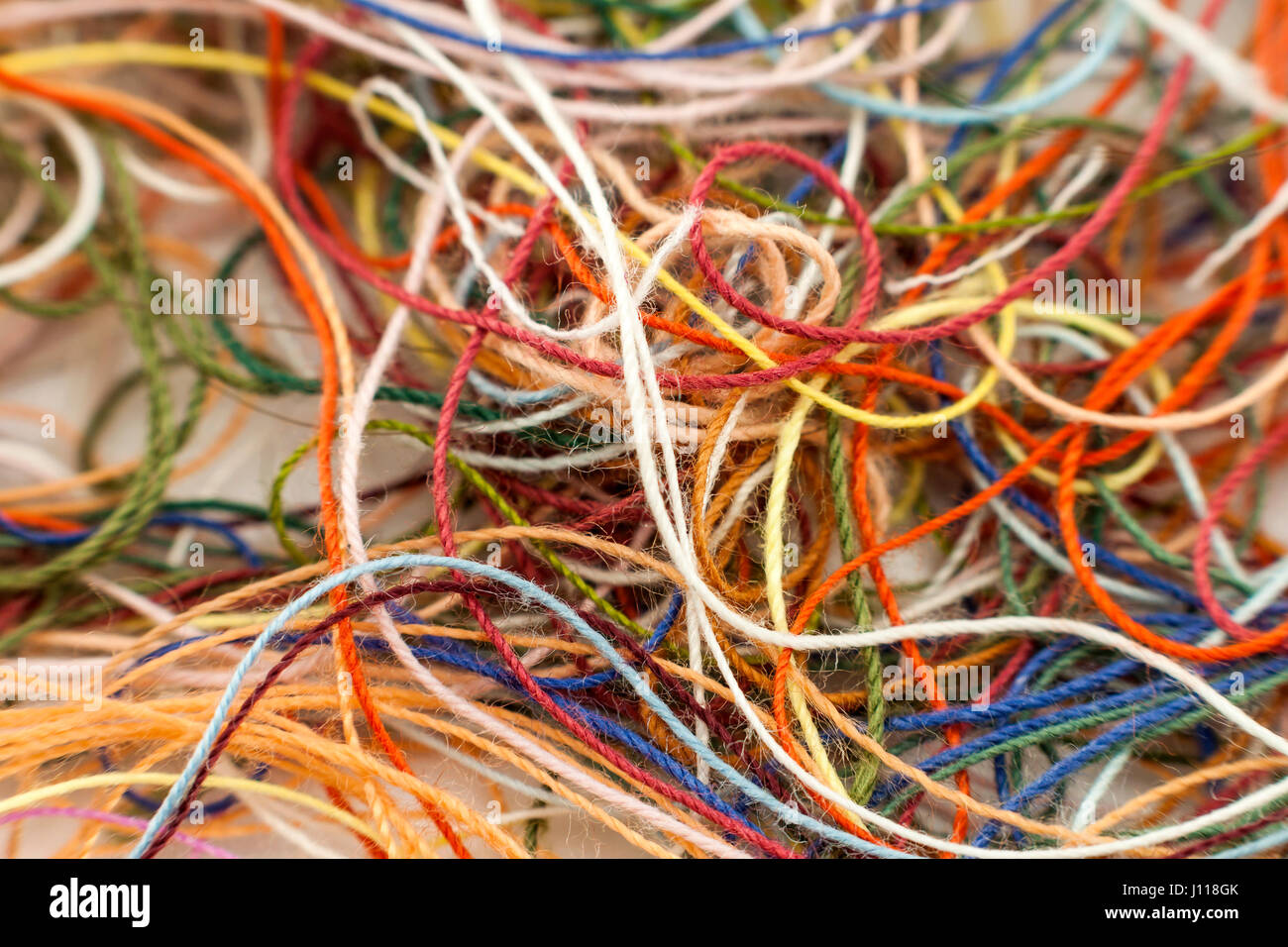 Multi-colored tangled colorful needlecraft silk thread rope. Macro shot ...