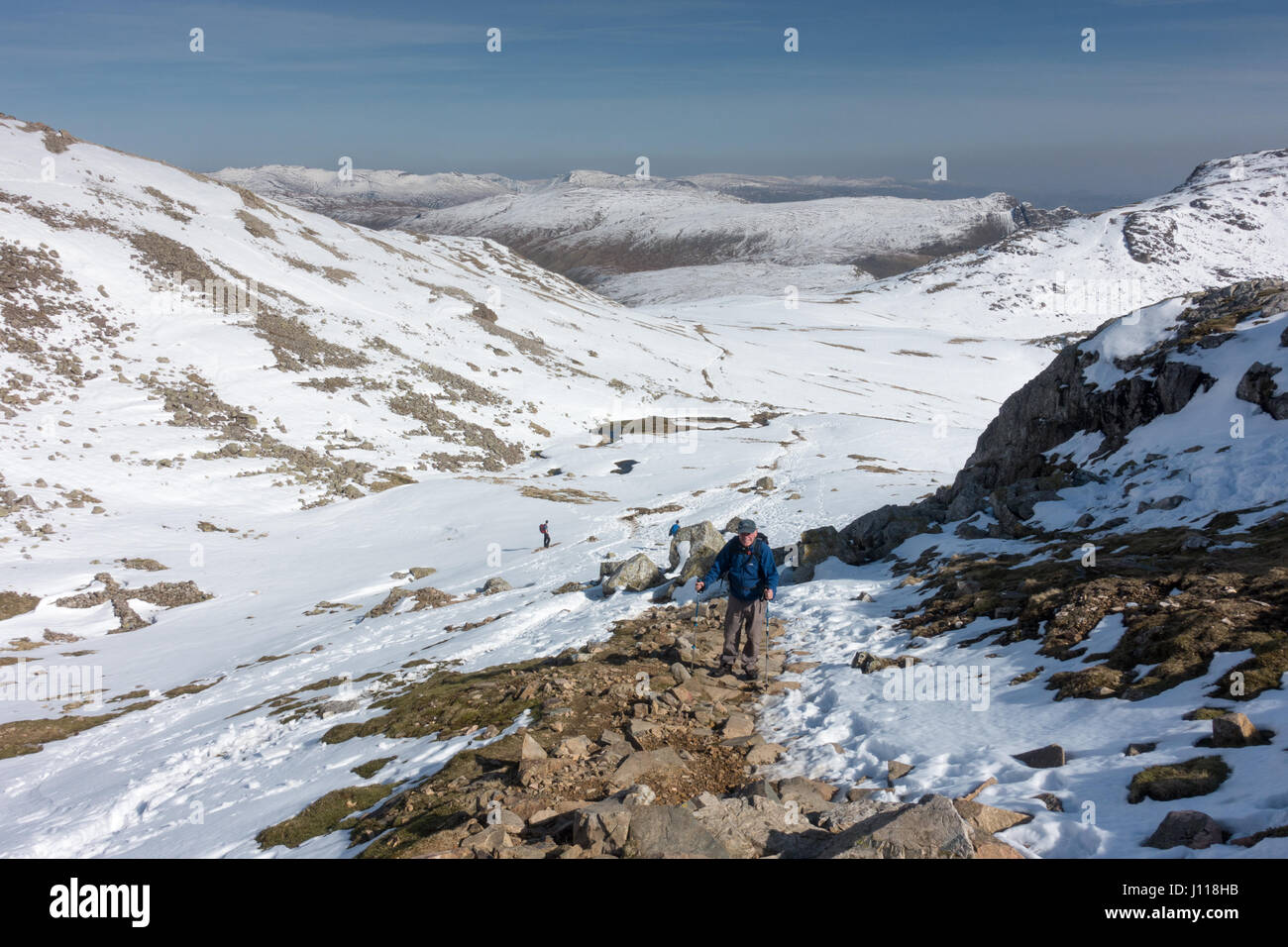 A walker ascending Calf Cove from Esk Hause with the Langdale Pikes ...
