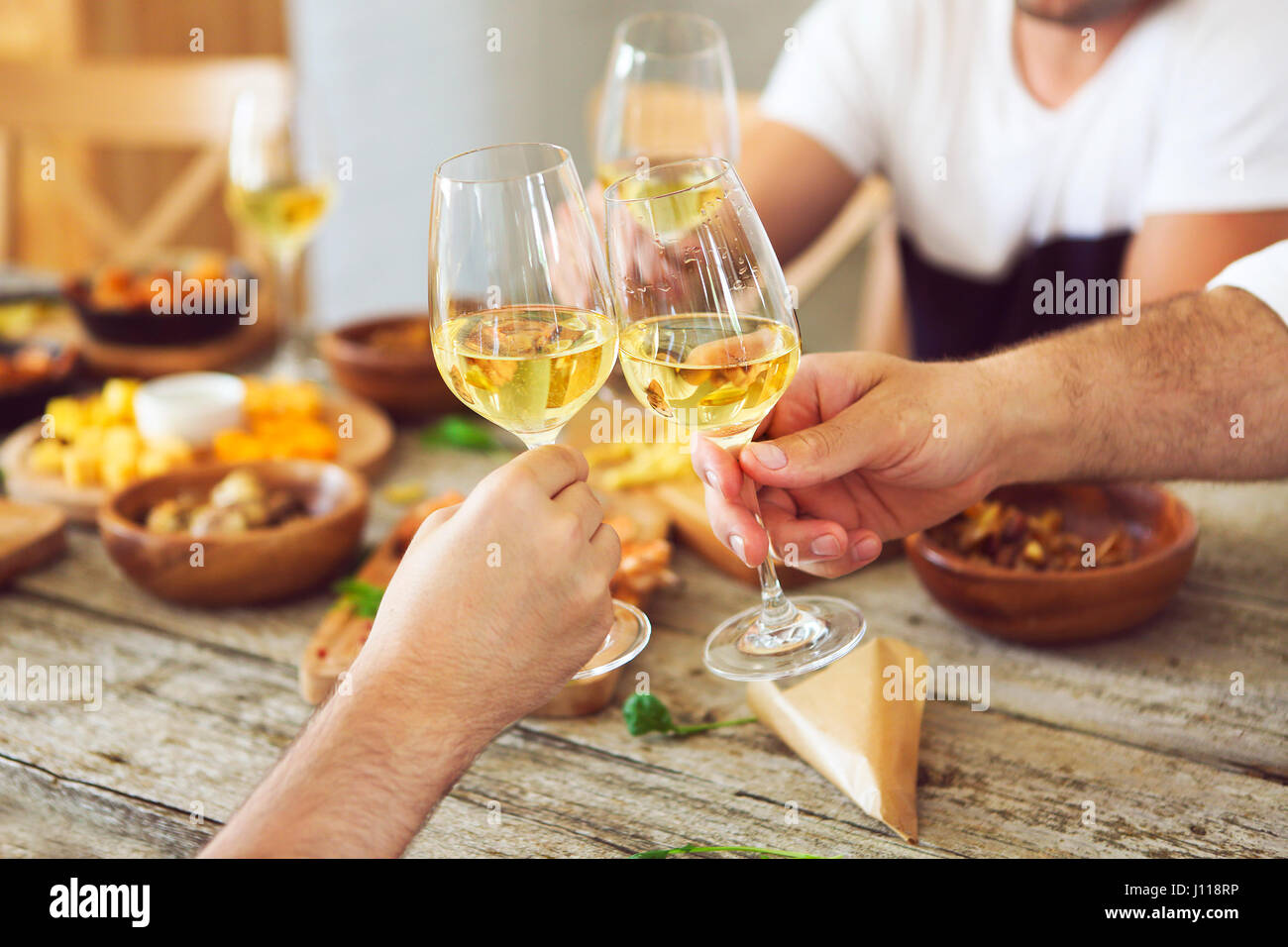Hands with white wine glasses. Dinner and celebration Stock Photo - Alamy