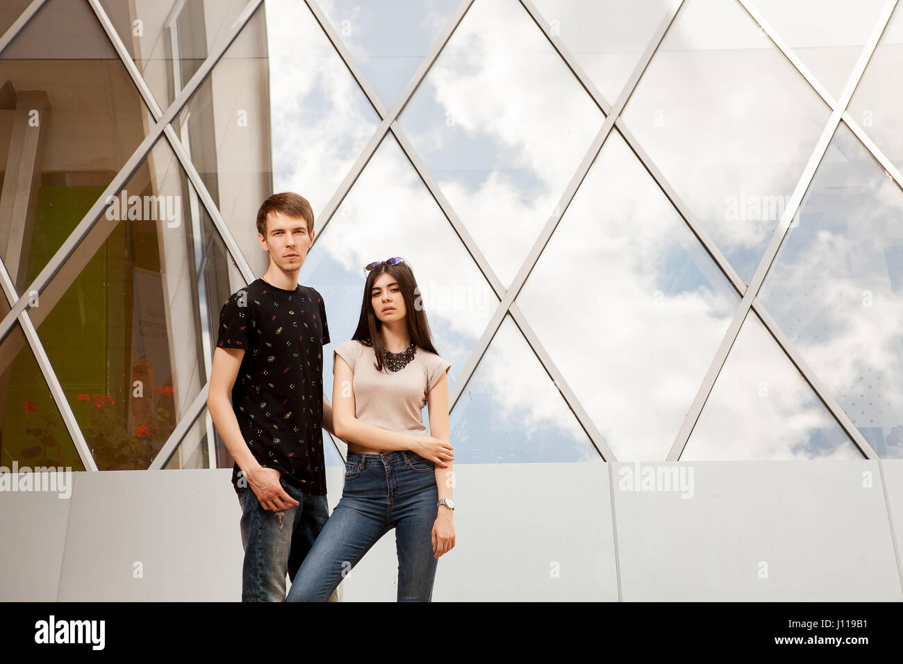 Couple posing in fashion style in front of glass building Stock Photo ...