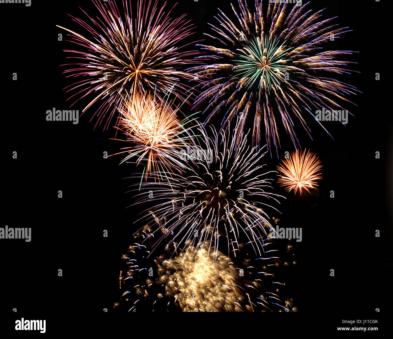 STACK OF MULTIPLE COMPLETE SMOKELESS FIREWORK BURSTS ON CLEAR BLACK SKY ...