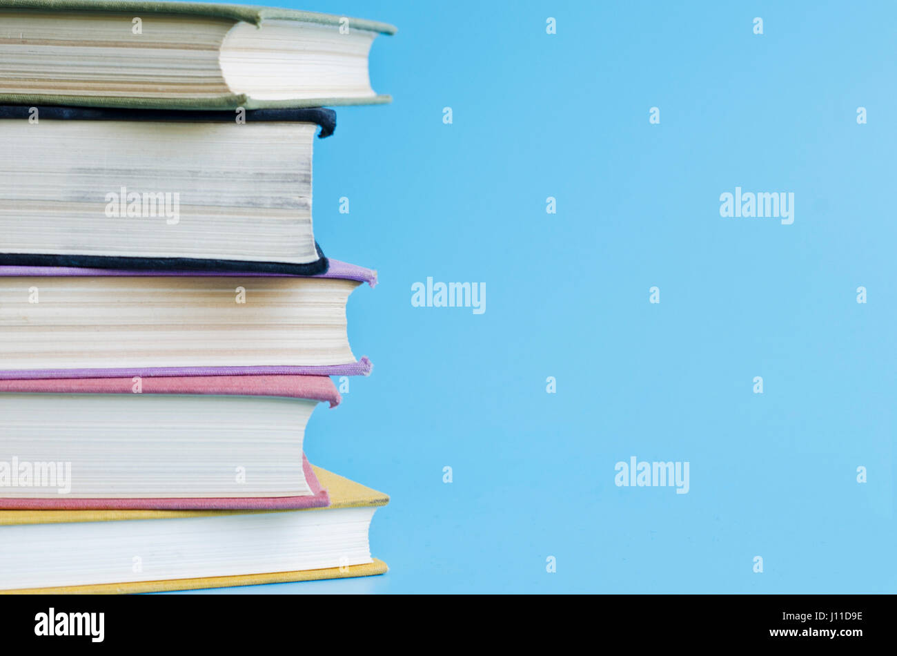 a stack of colorful books on a blue background in library Stock Photo ...