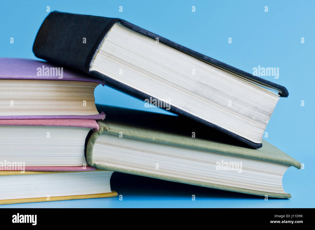 a stack of colorful books on a blue background in library Stock Photo ...