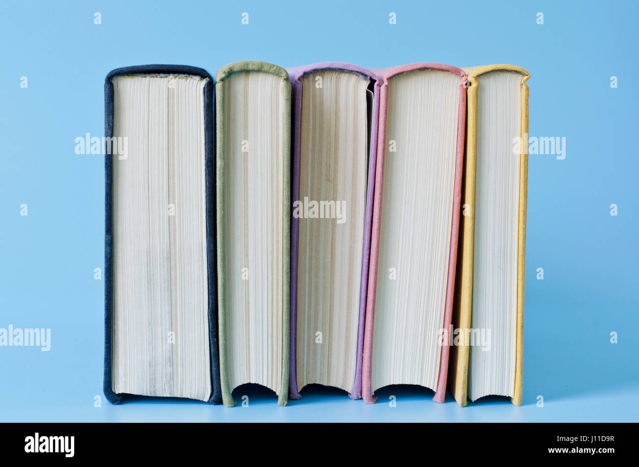 a stack of colorful books on a blue background in library Stock Photo ...