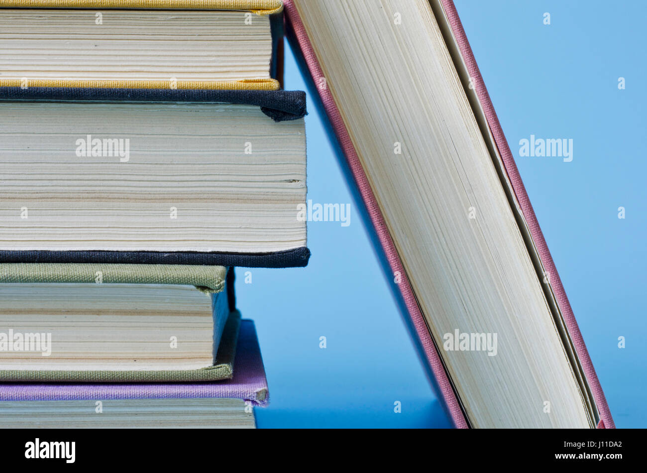 a stack of colorful books on a blue background in library Stock Photo ...