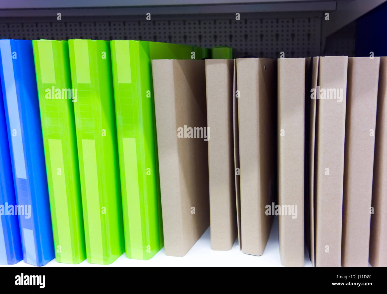 Green, blue and cardboard folders standing on store shelf Stock Photo ...