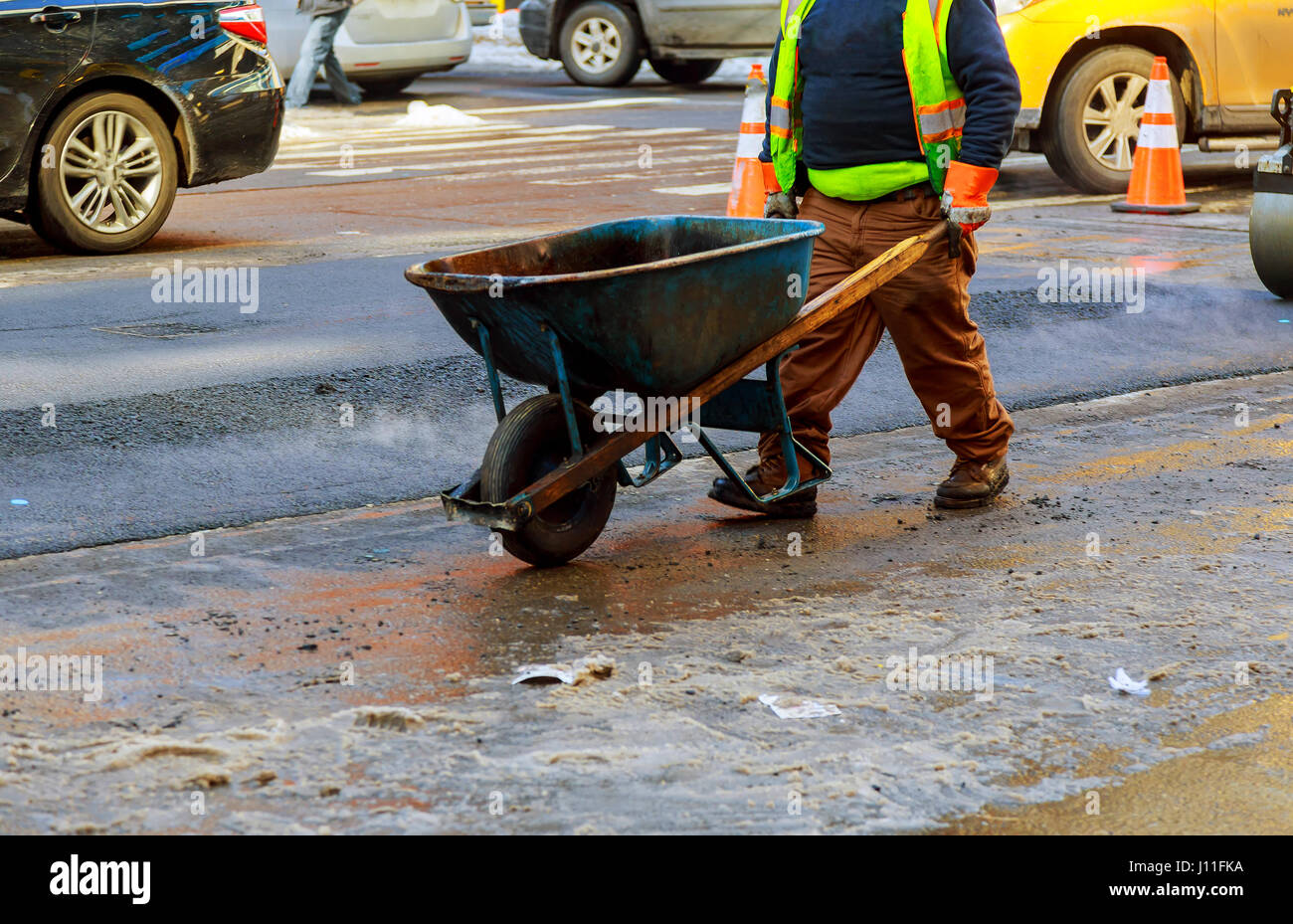 Men hard working on asphalting road with shovels men road is under ...