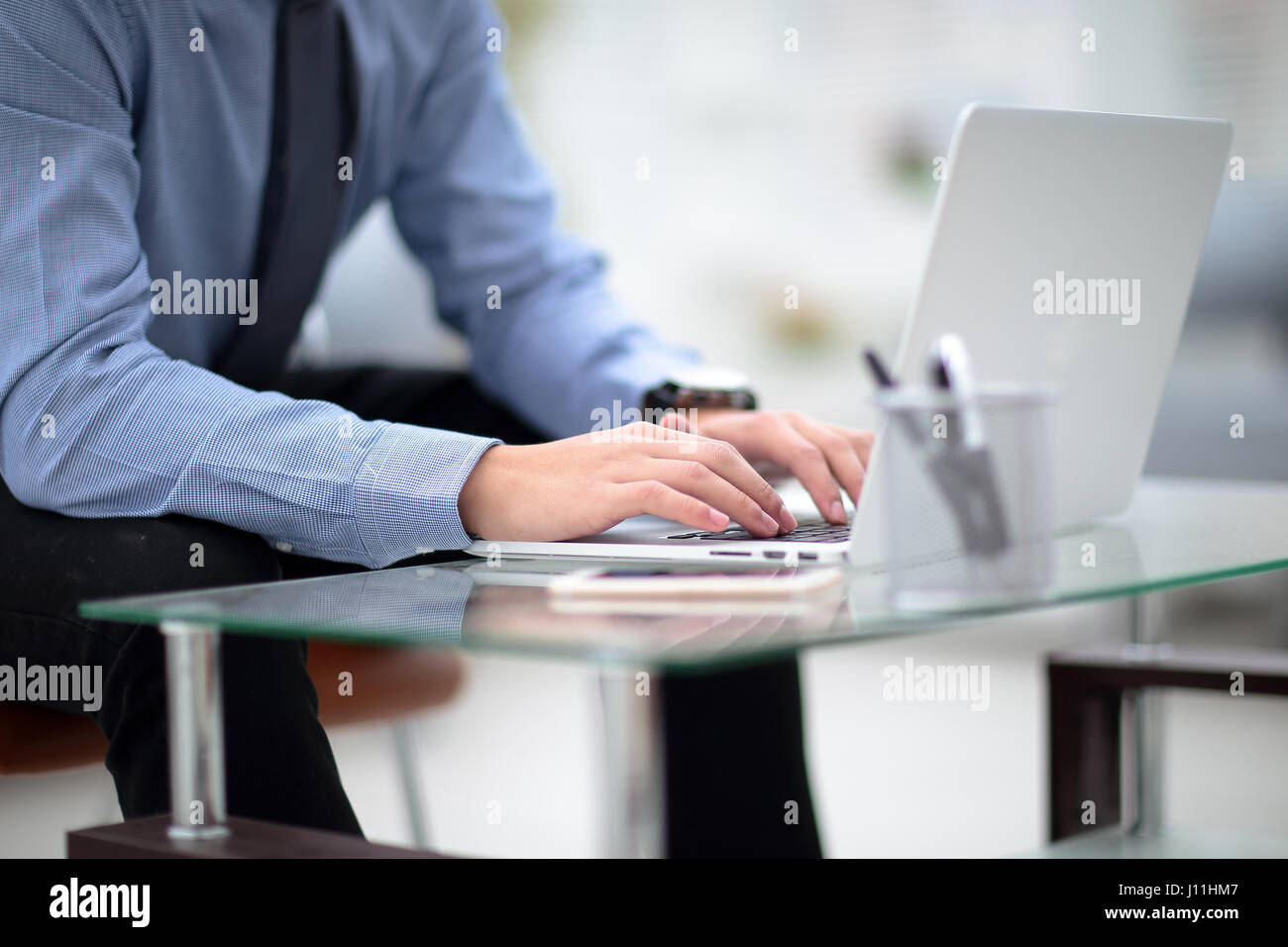 Young business man working on a laptop at his desk in the office, in ...