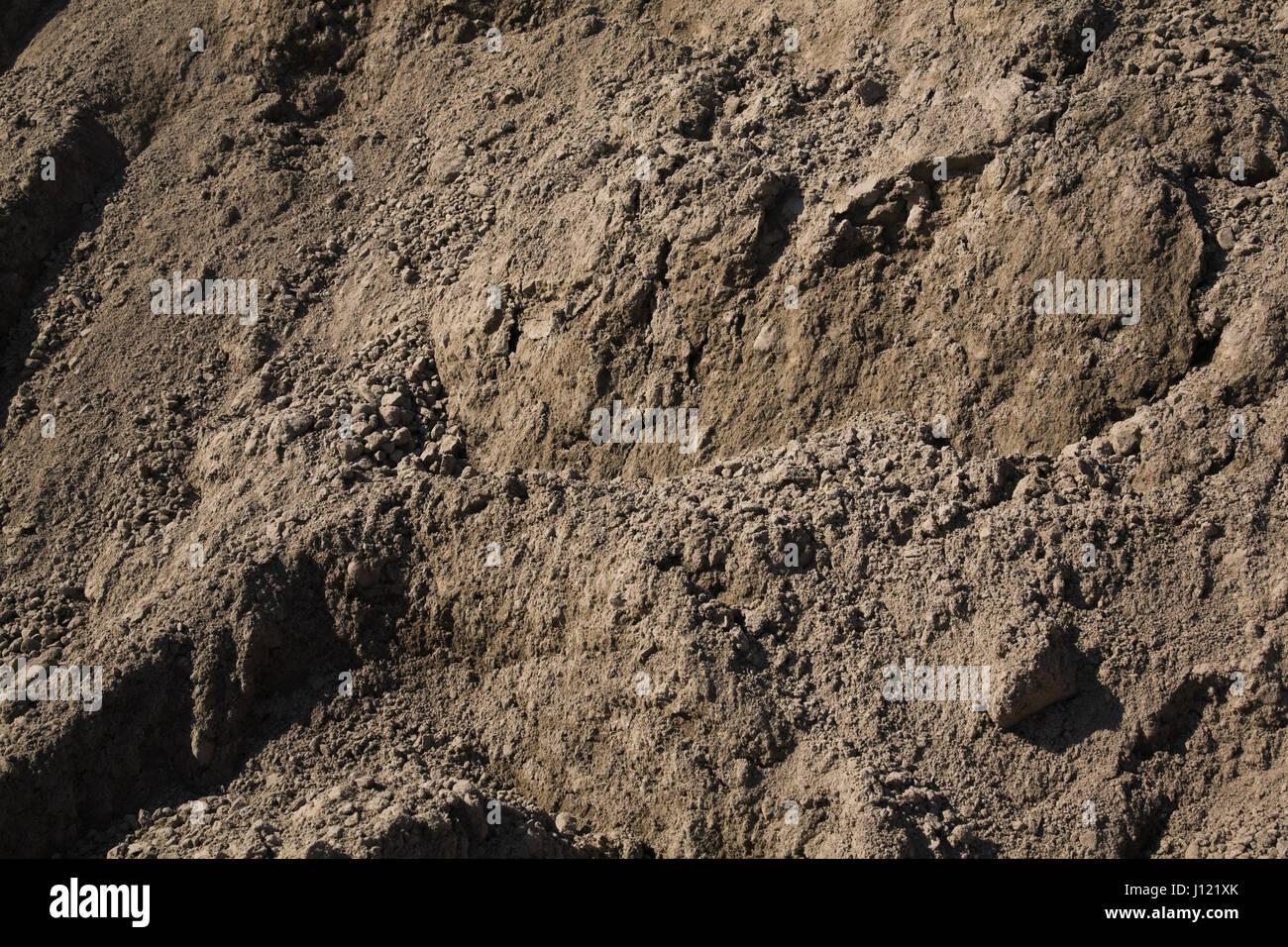 Close-up of lumps of sand in a mound of sand on a construction site ...