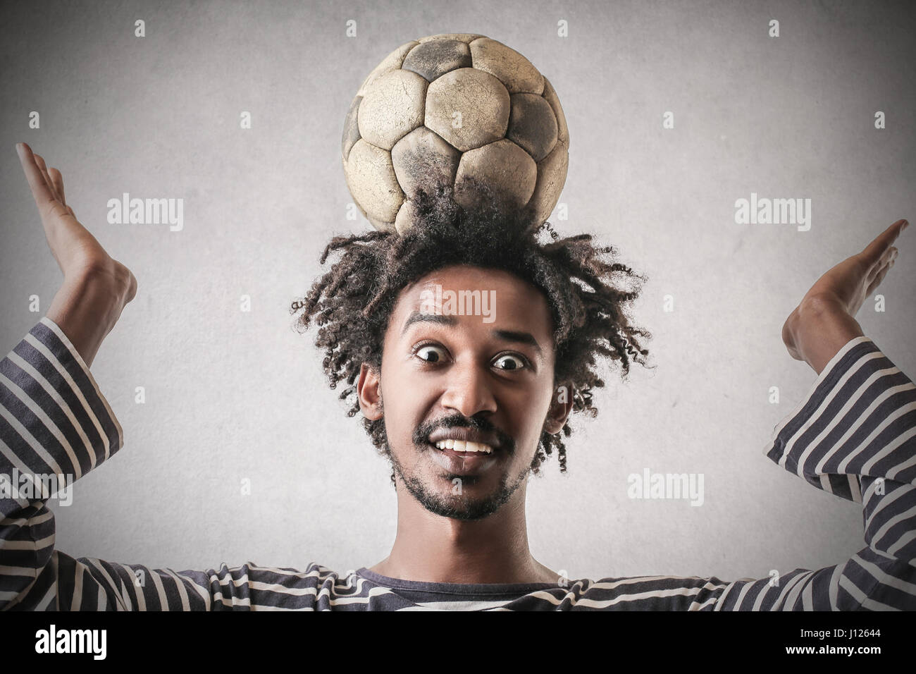 Young black man with football on his head Stock Photo - Alamy