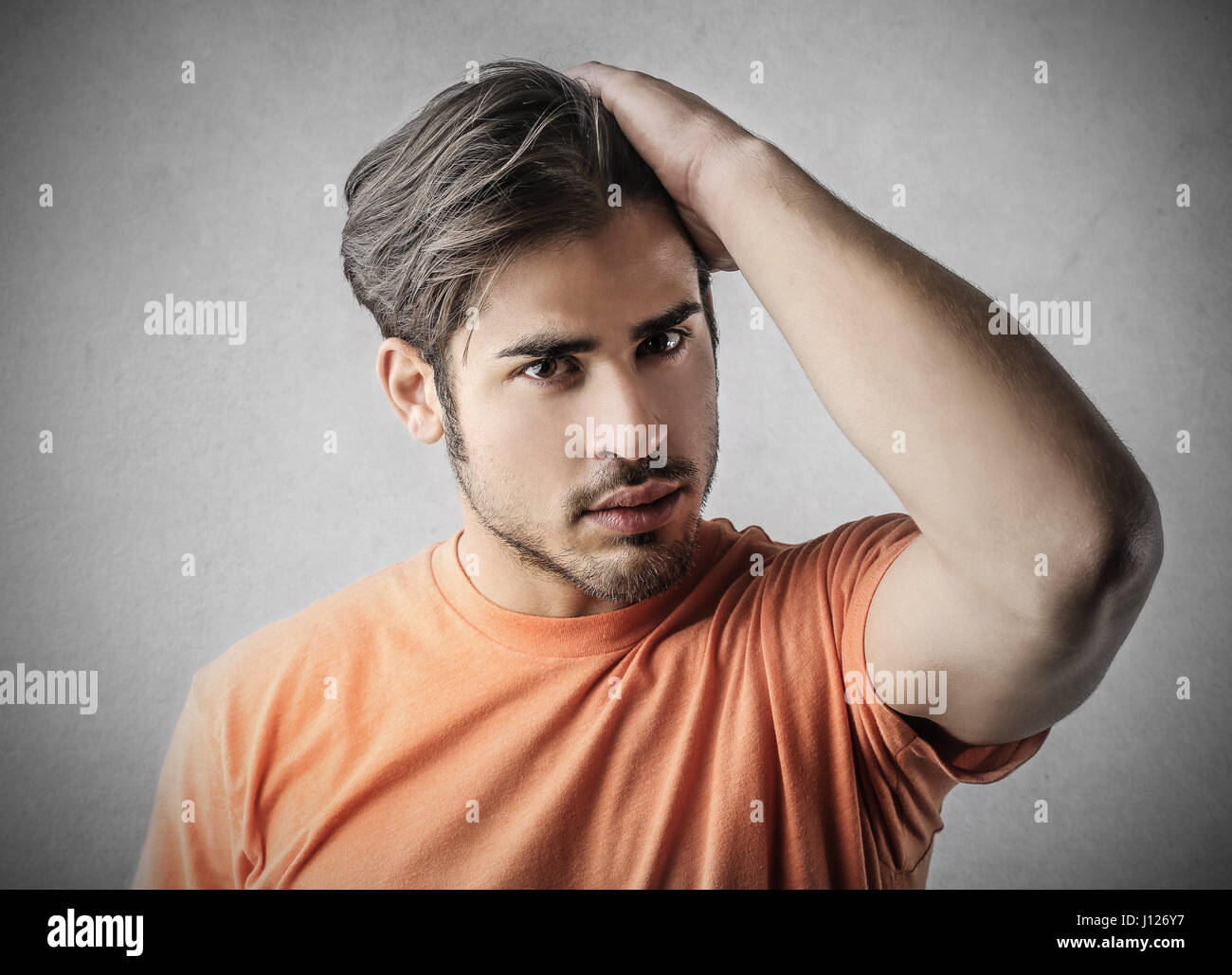 Man in orange shirt being handsome Stock Photo - Alamy