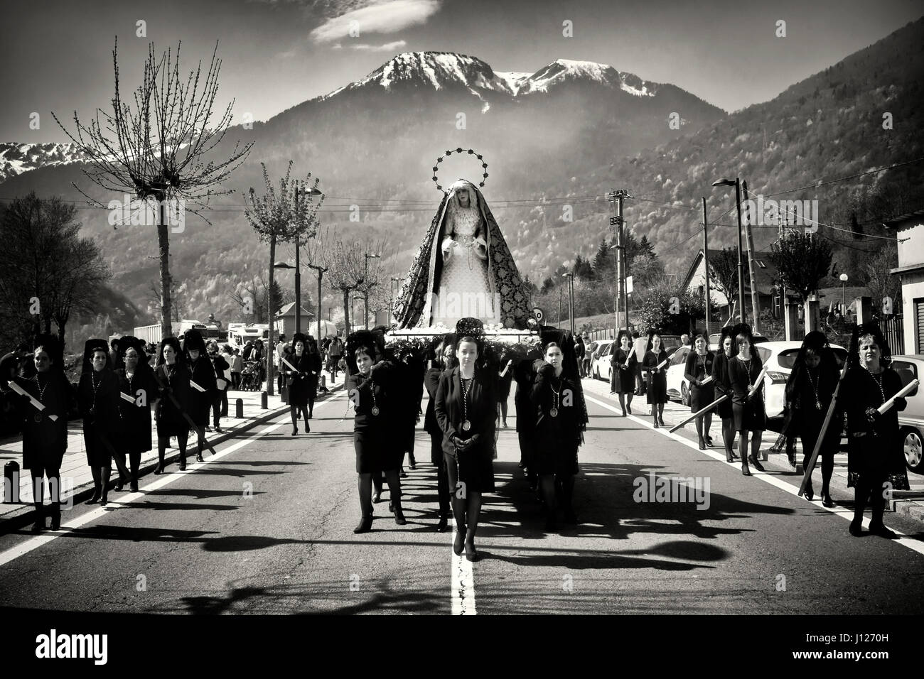 Women wearing the traditional mantilla carry a wooden image ...