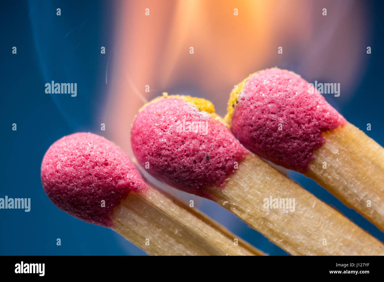 Burning safety matches. Blue background Stock Photo - Alamy