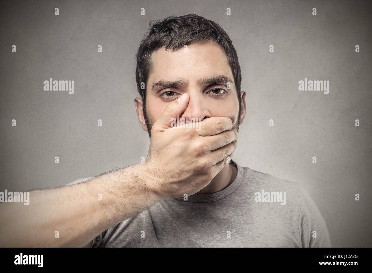 Man covering his mouth Stock Photo - Alamy