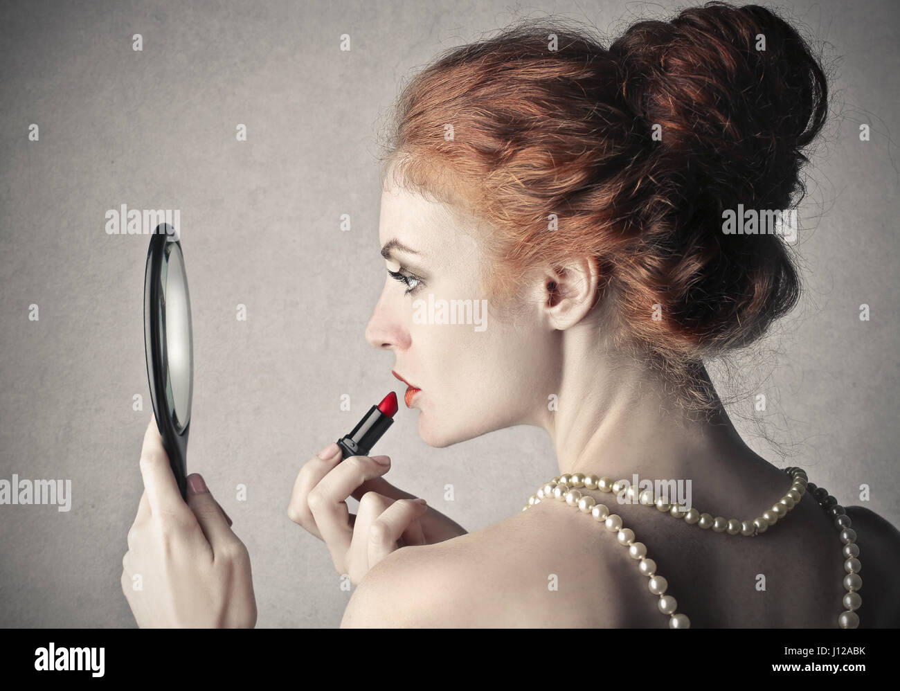 Elegant woman doing her makeup Stock Photo - Alamy