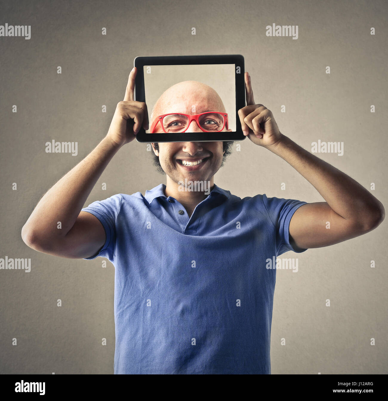 Man with tablet and other face Stock Photo - Alamy