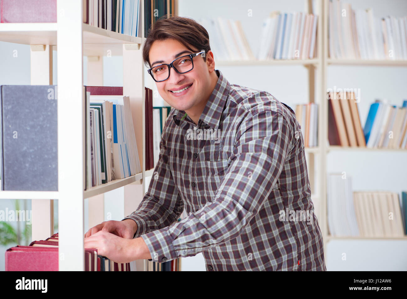 Young student looking for books in college library Stock Photo - Alamy