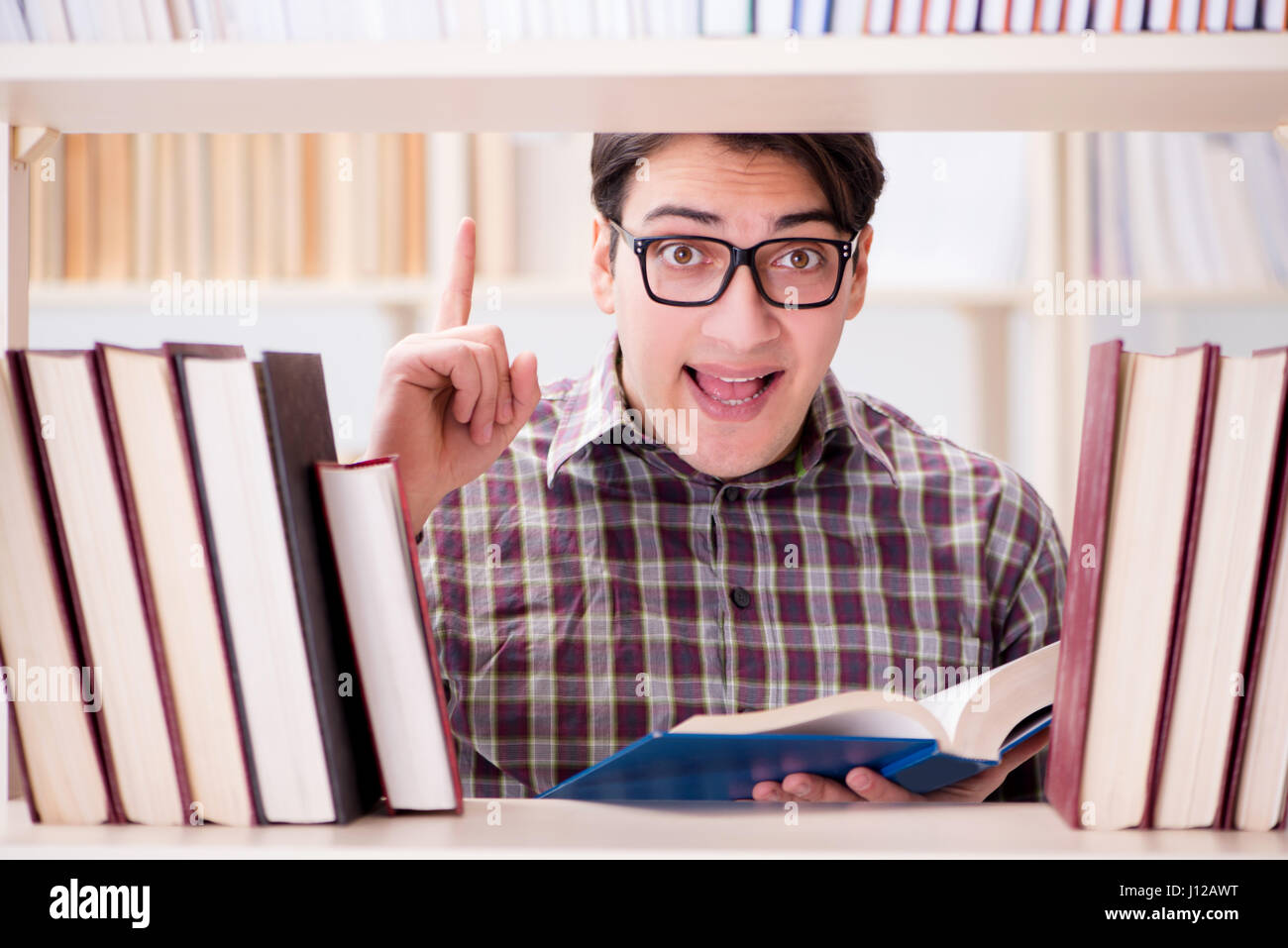Young student looking for books in college library Stock Photo - Alamy