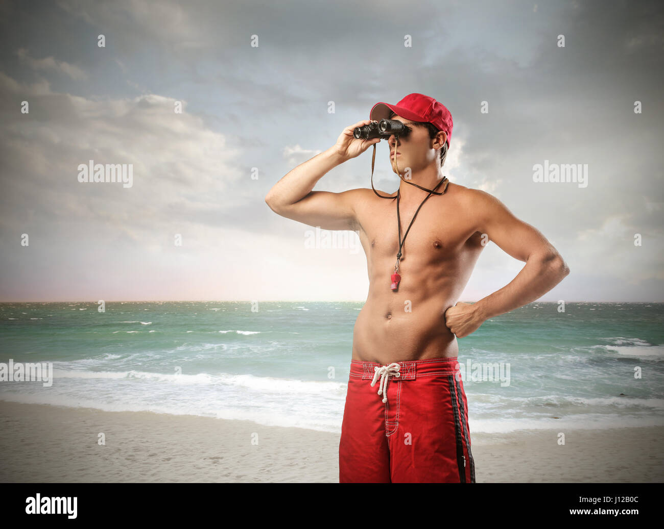 Life guard man on the beach with telescope Stock Photo - Alamy