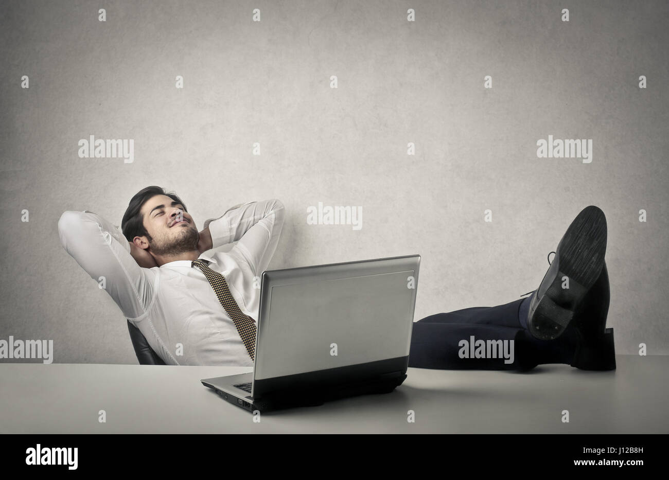 Businessman relaxing at work Stock Photo - Alamy