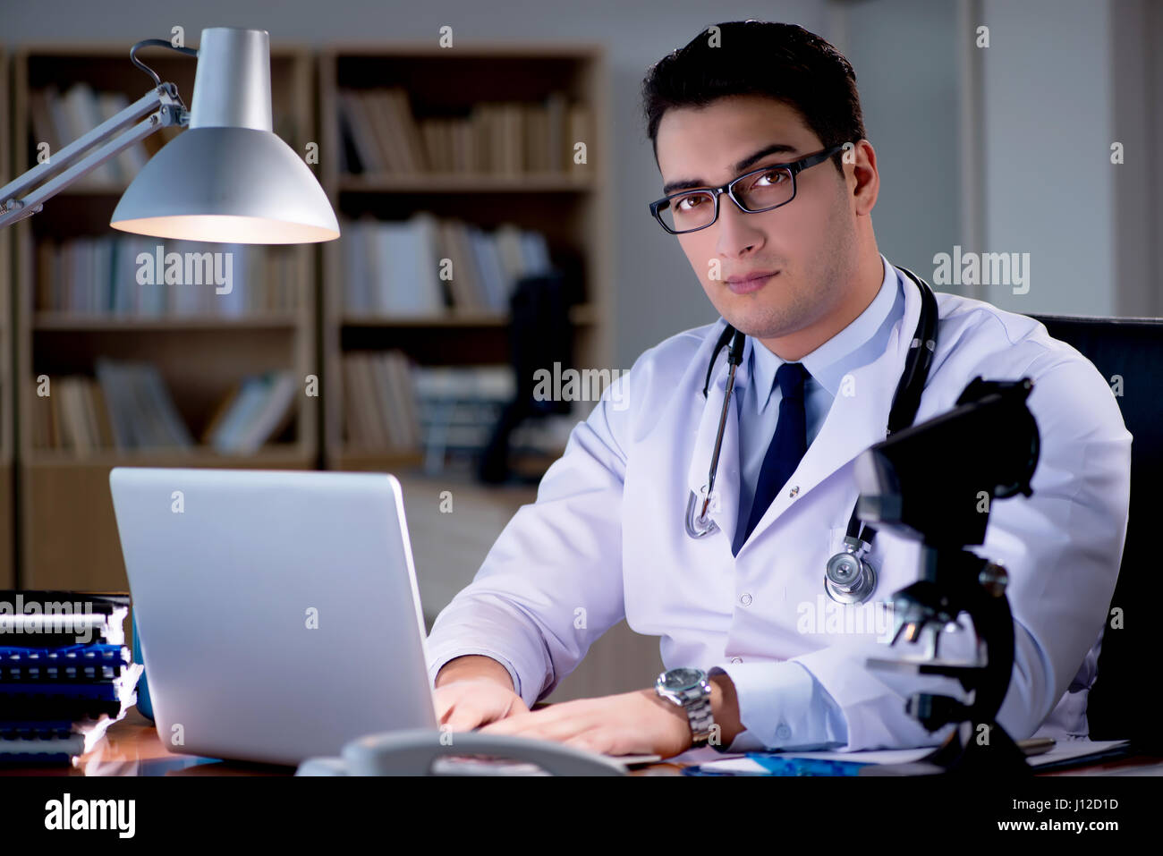 Young doctor working late in the office Stock Photo - Alamy