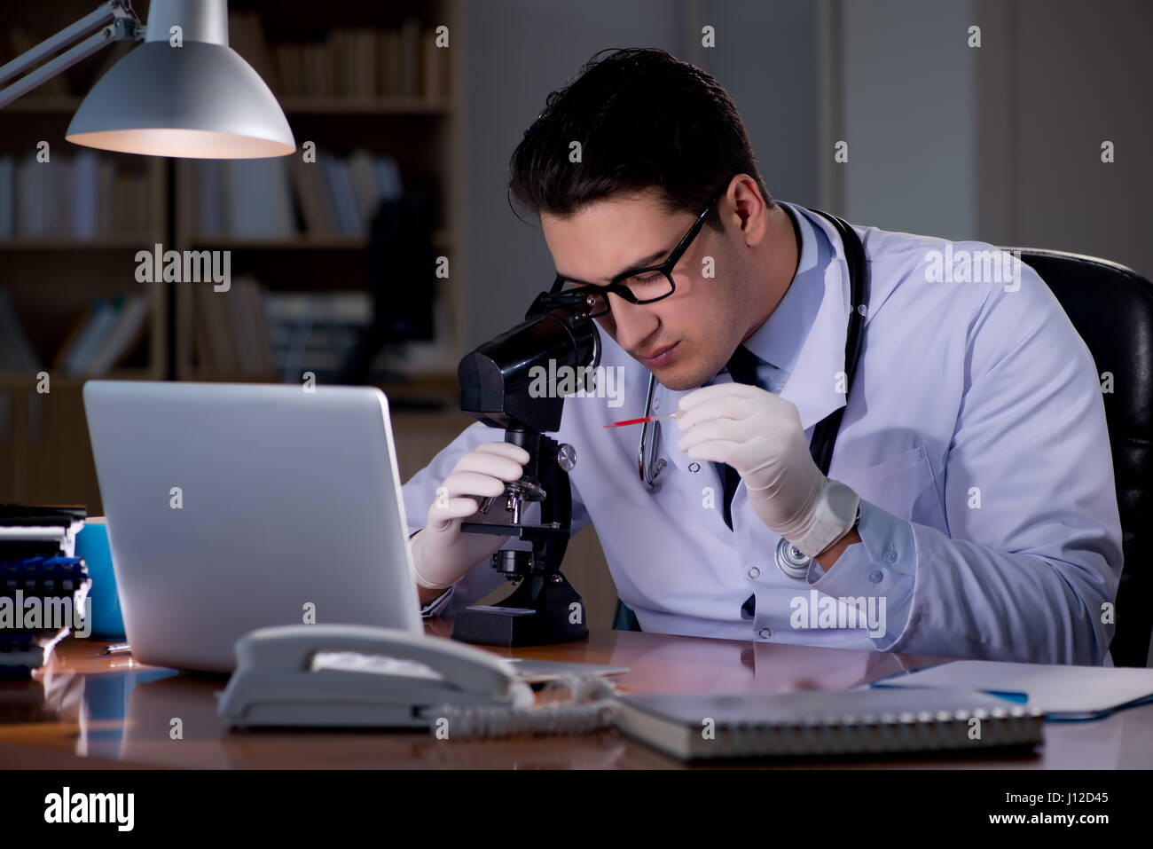 Young doctor working late in the office Stock Photo - Alamy