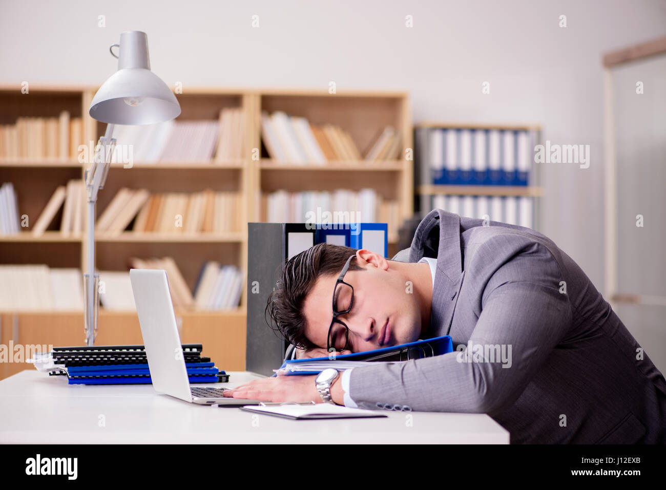 Sleepy businessman working in office Stock Photo - Alamy