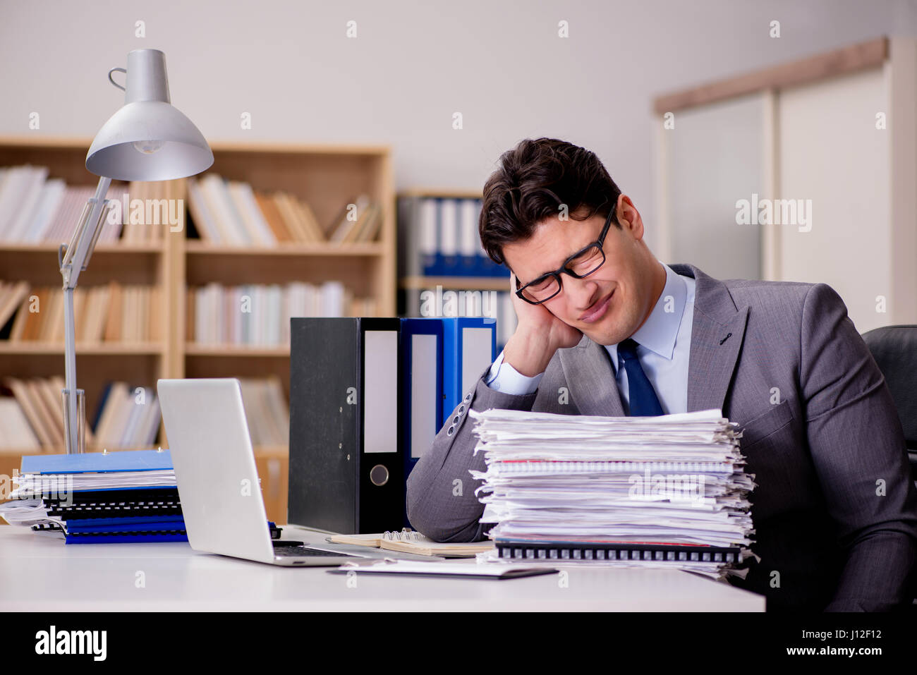 Businessman with too much paperwork Stock Photo - Alamy