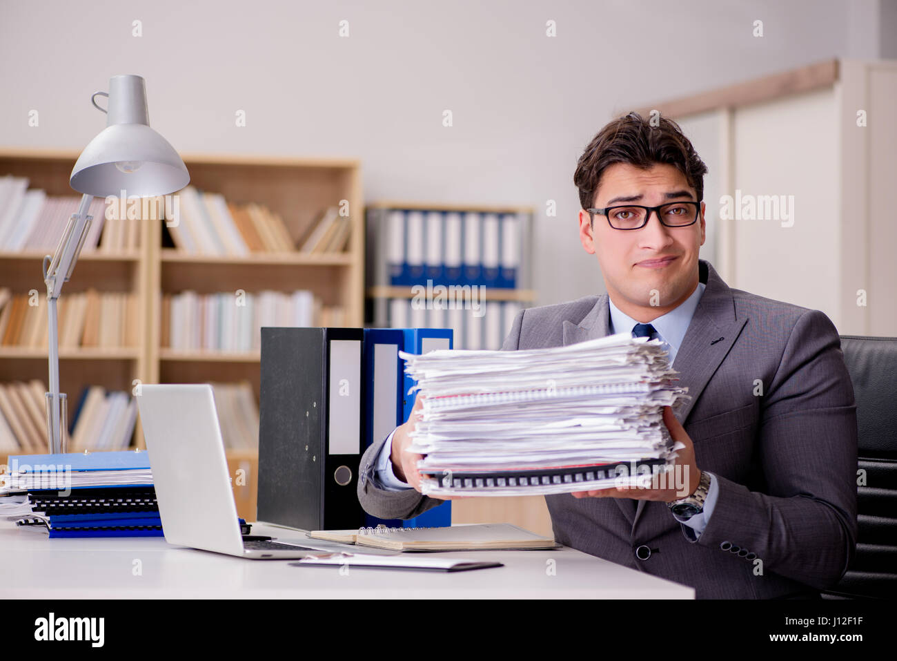 Businessman with too much paperwork Stock Photo - Alamy