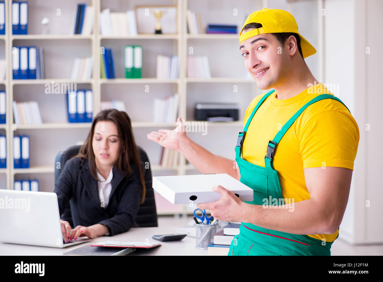 Postman delivering parcel to the office Stock Photo - Alamy