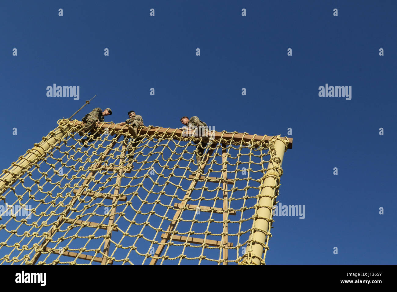 U.S. Servicemembers climb over the top of the ‘Tough One’ obstacle ...