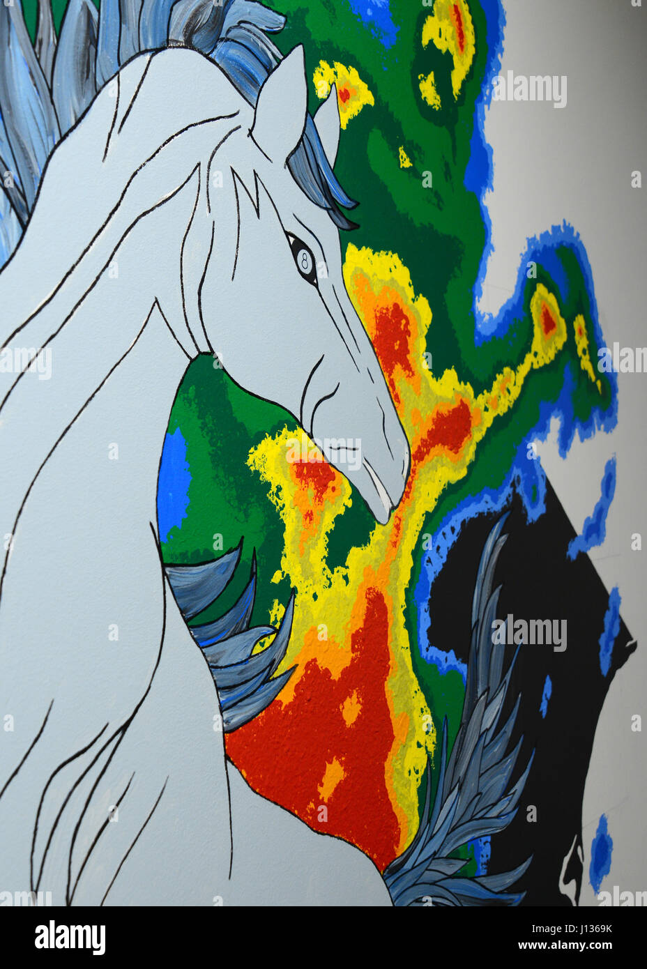 A mural depicting a mustang and radar image is displayed on a wall ...