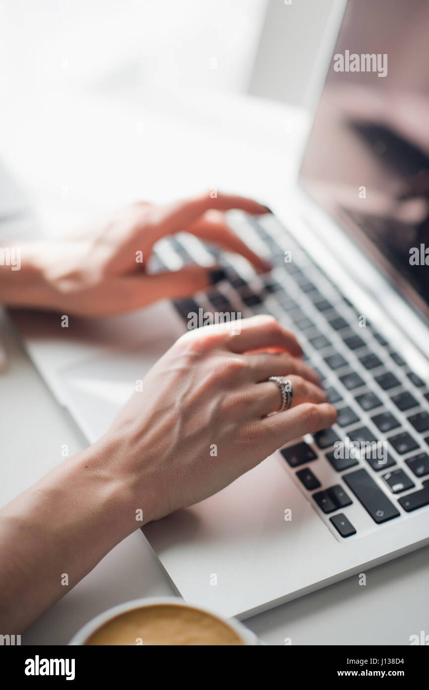 Close-up picture of woman's hands typing a message on her laptop during ...