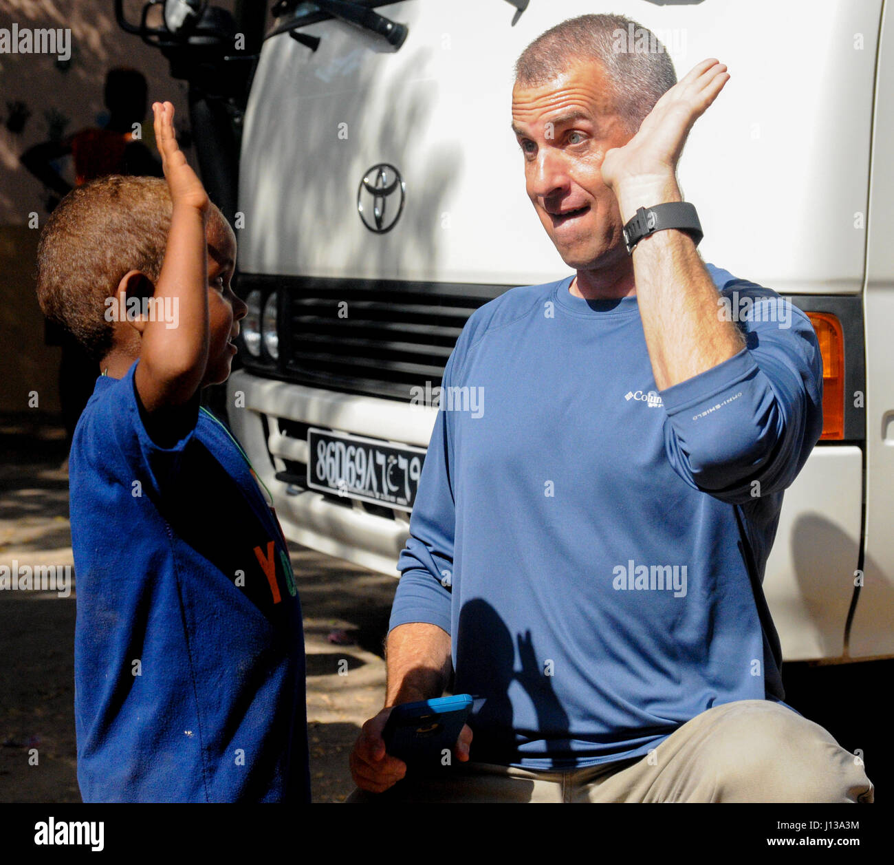 U.S. Army Col. Kevin Koehler, the battalion surgeon, gives a small boy ...