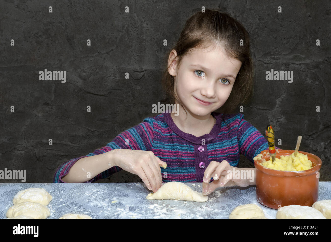 Little girl sculpts patties with potatoes Stock Photo - Alamy