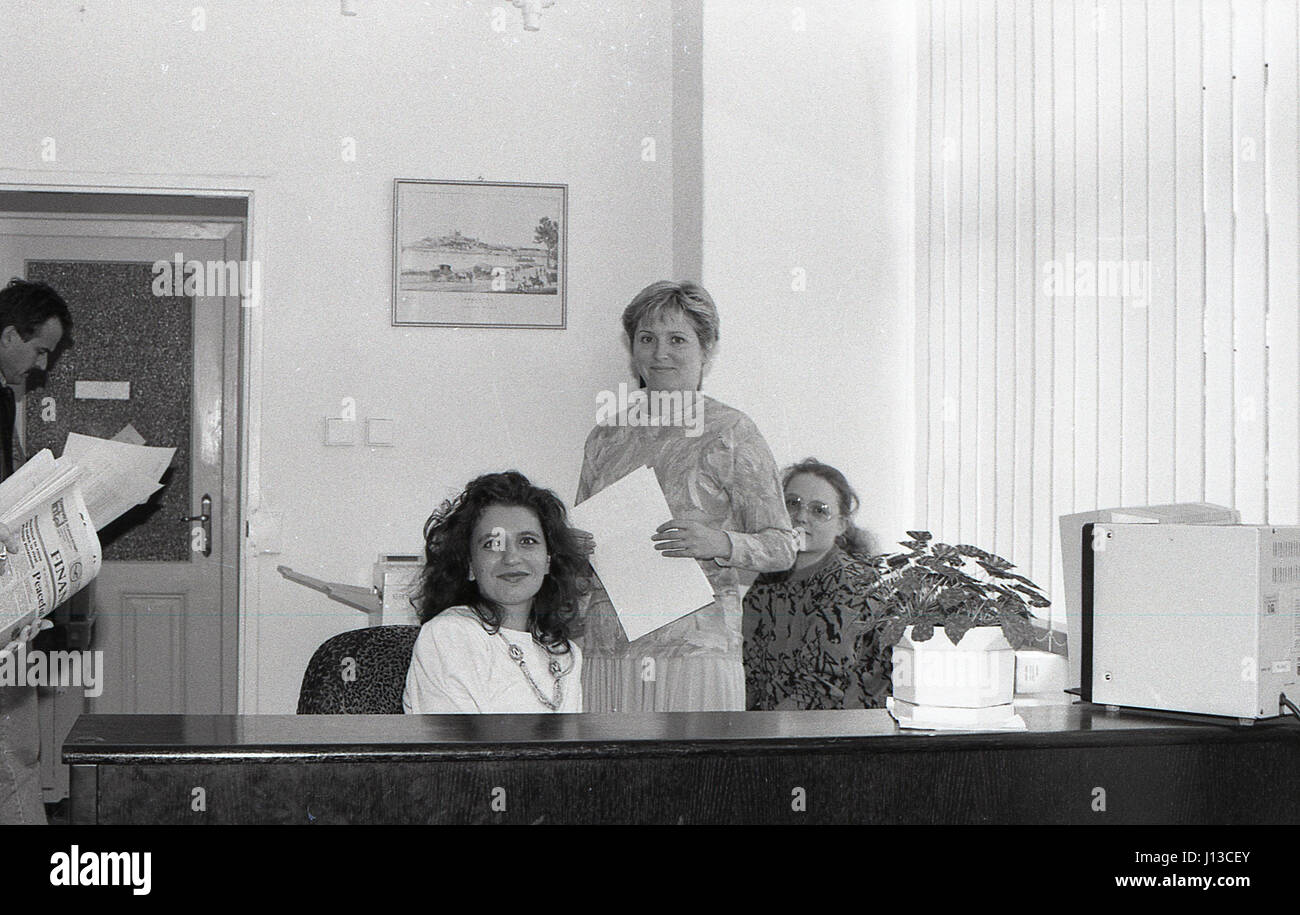 Three women and a man pose together in an office setting for a ...
