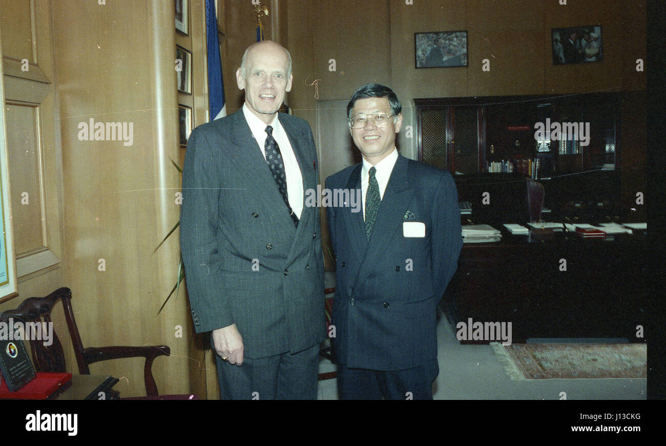 Two men stand together taking a photograph, demonstrating documentation ...