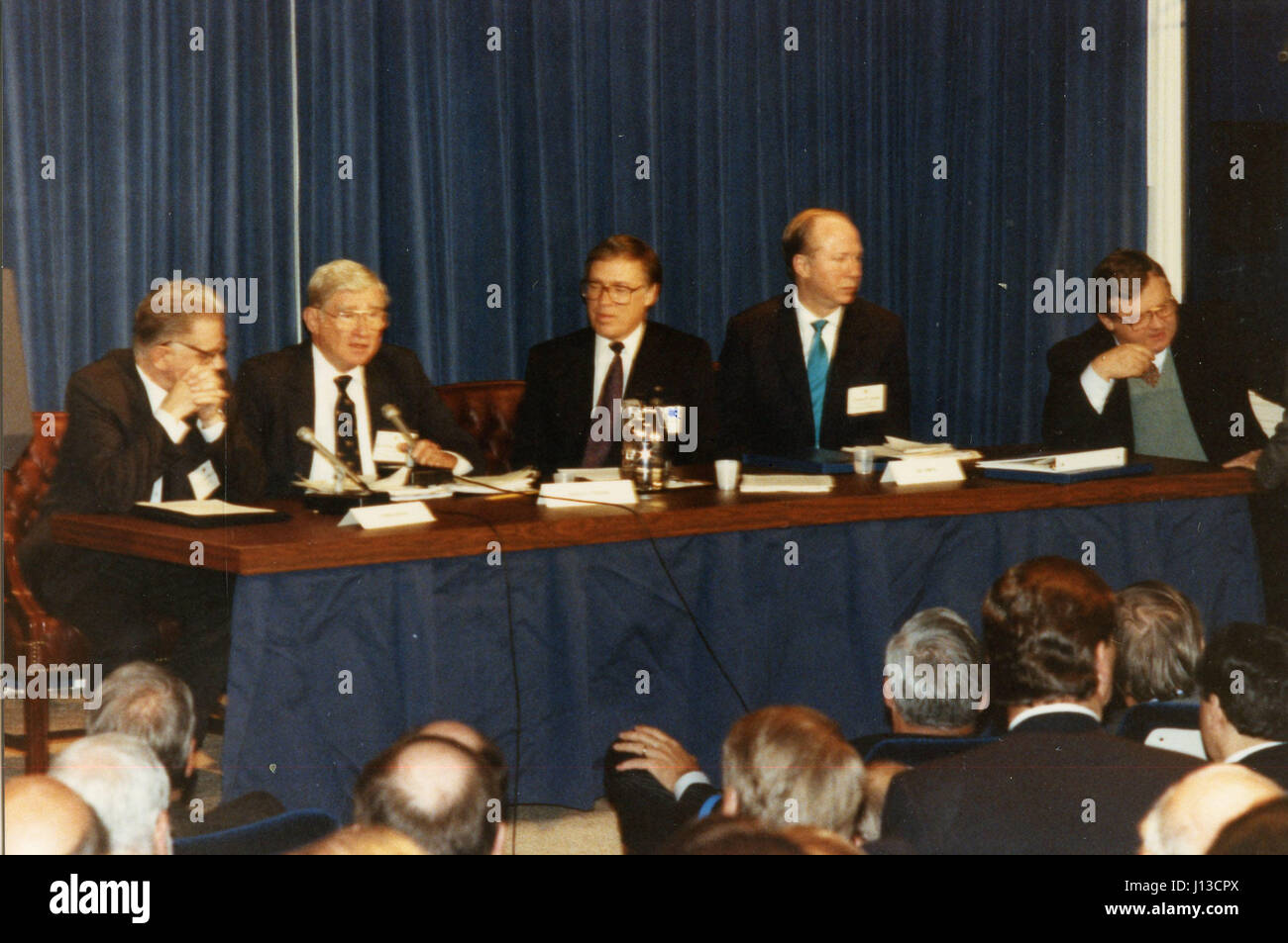 THERE ARE FIVE MEN SITTING AT THE TABLE HAVING A CONVERSATION WITH A ...