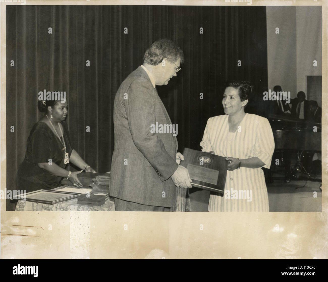 A woman receives a formal award from a man during a ceremony ...