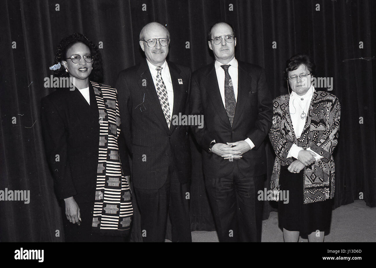 A group of men and women pose together for a formal photograph ...