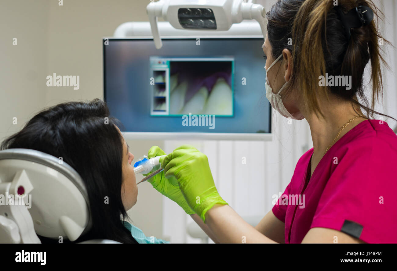 Dentist examining woman's teeth with camera Stock Photo - Alamy