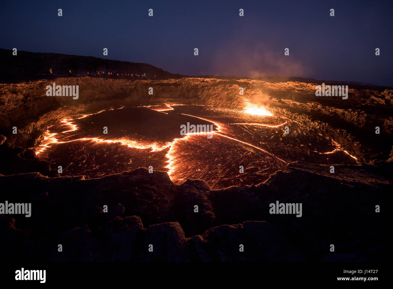 AFAR REGION, ETHIOPIA: Visitors stand around the rim of the lava lake ...