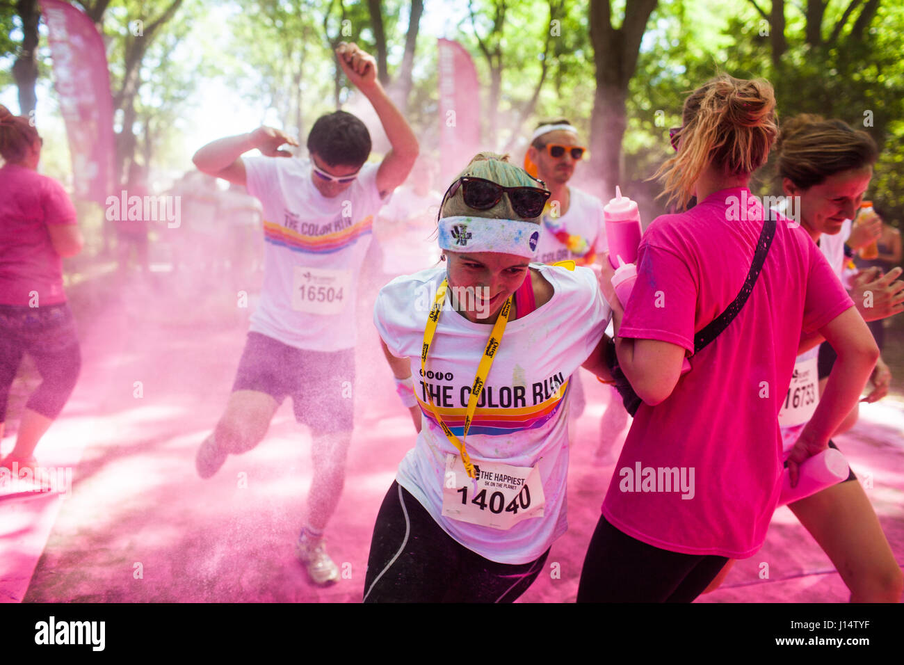 The many color runners have fun and are here passing the pink color ...